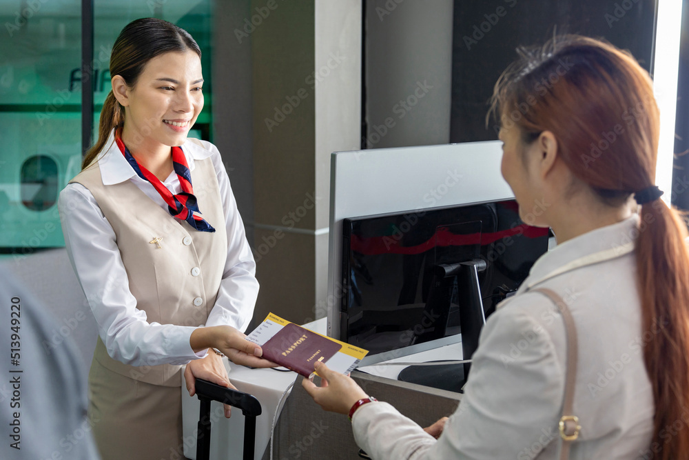 Asian passenger is showing her boarding pass to the airline ground crew ...
