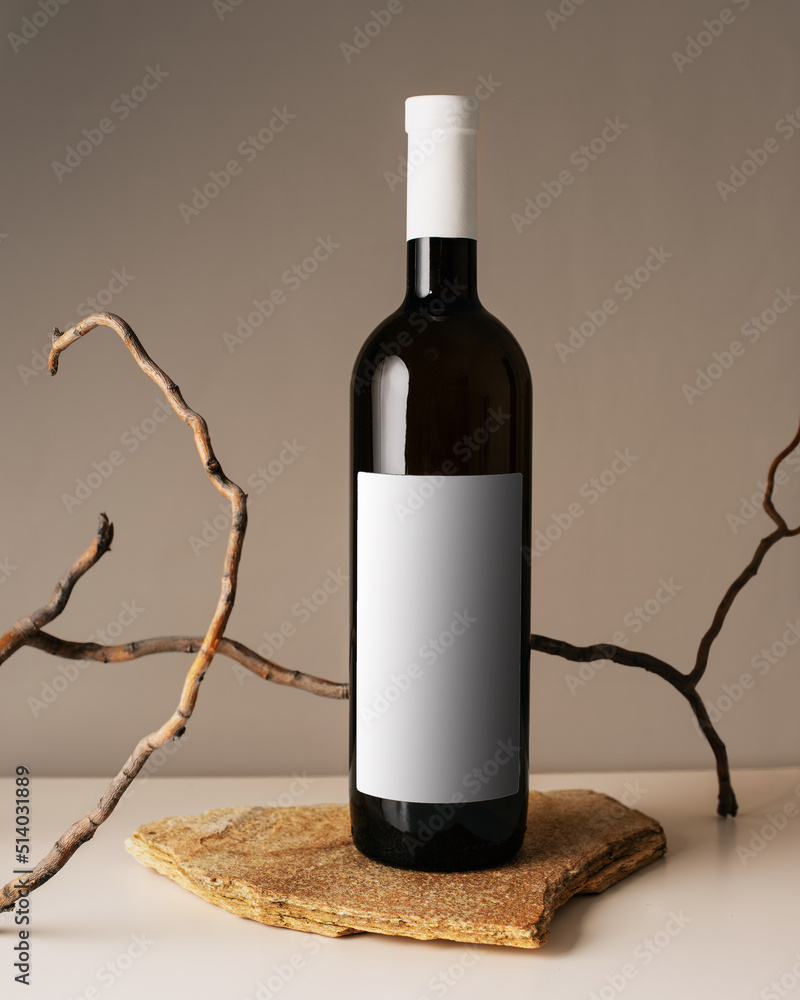 Blank white label mock up on black bottle of unlabeled wine on a table ...