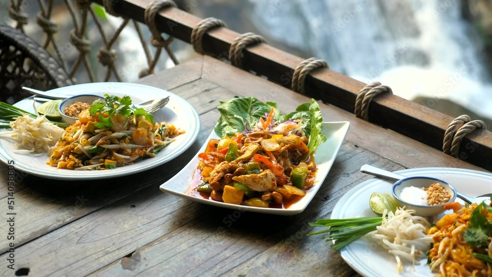 Traditional thai food in outdoor cafe with nature waterfall background ...