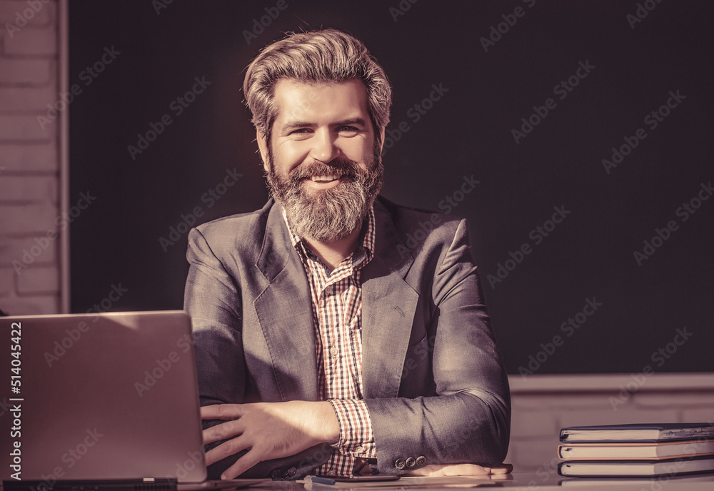 Portrait of confident male teacher in classroom. Young male teacher ...