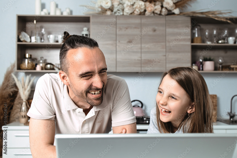 Dad and daughter look at the laptop Stock Photo | Adobe Stock