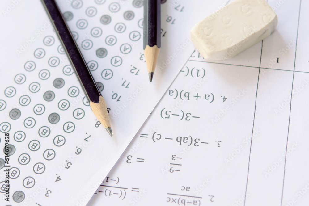 Pencil and eraser on answer sheets or Standardized test form with ...