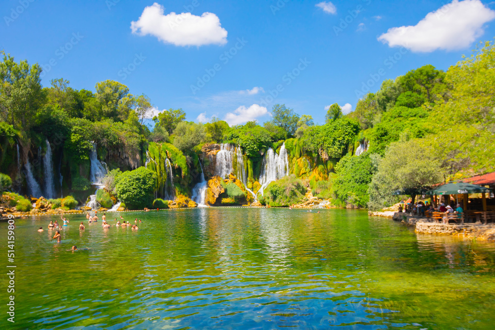 Small boat rowing just under Kravica waterfalls in southern Bosnia and ...