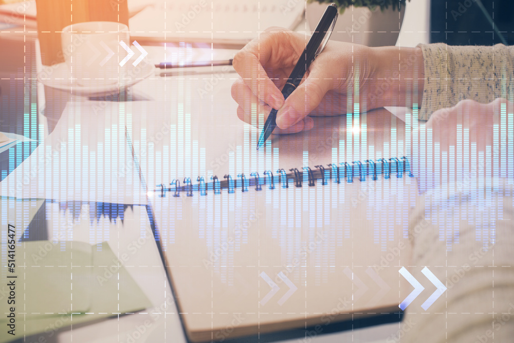 Hand taking notes in notepad. Forex chart holograms in front. Concept ...