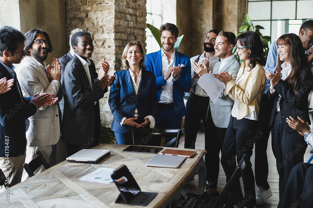 Multiracial business people celebrating together inside office - Focus ...