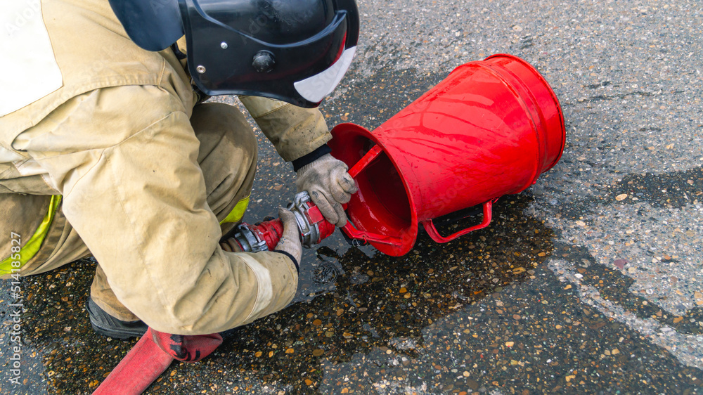 A firefighter in a protective suit and helmet.A firefighter holds a ...
