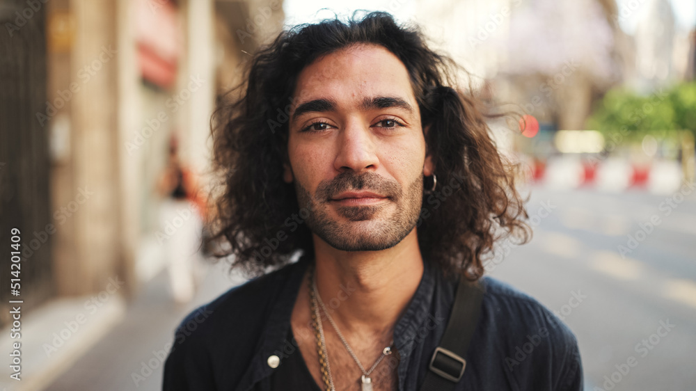 Young attractive italian guy with long curly hair and stubble looks ...