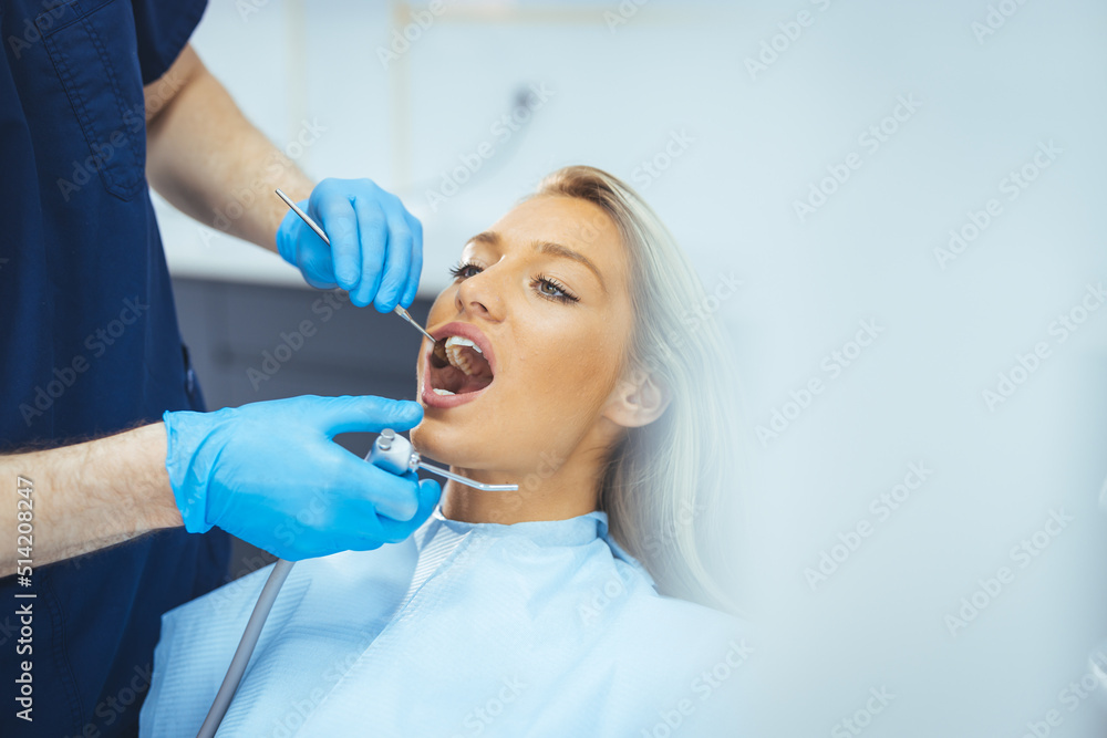 Dentist and patient in dentist office. Over the shoulder view of a ...