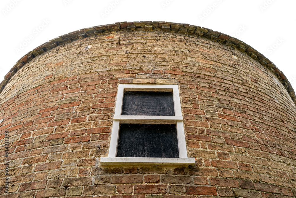 Architectural view of a very old round house which shows the brick wall ...