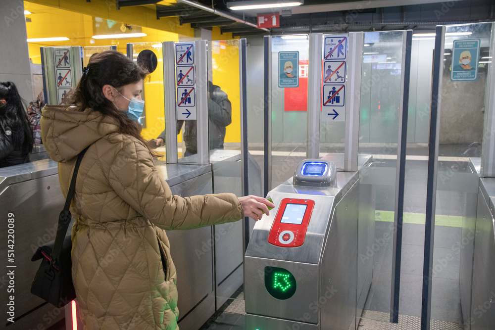 a young woman in a hygienic mask scans a card at the terminal in the ...