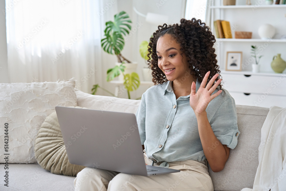 Happy African teen girl waving using laptop computer enjoying online ...