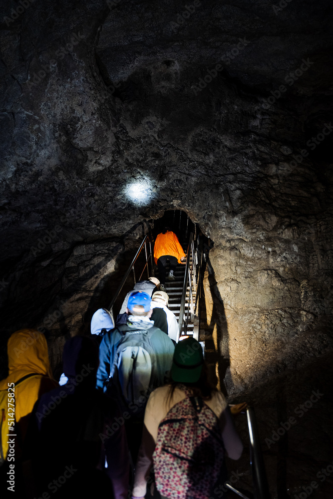 Tourists explore an underground cave, a group of people stuck deep ...