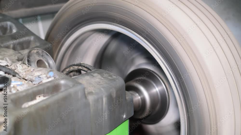 Tire balancing car service. The tire fitter puts the tire on the car's ...