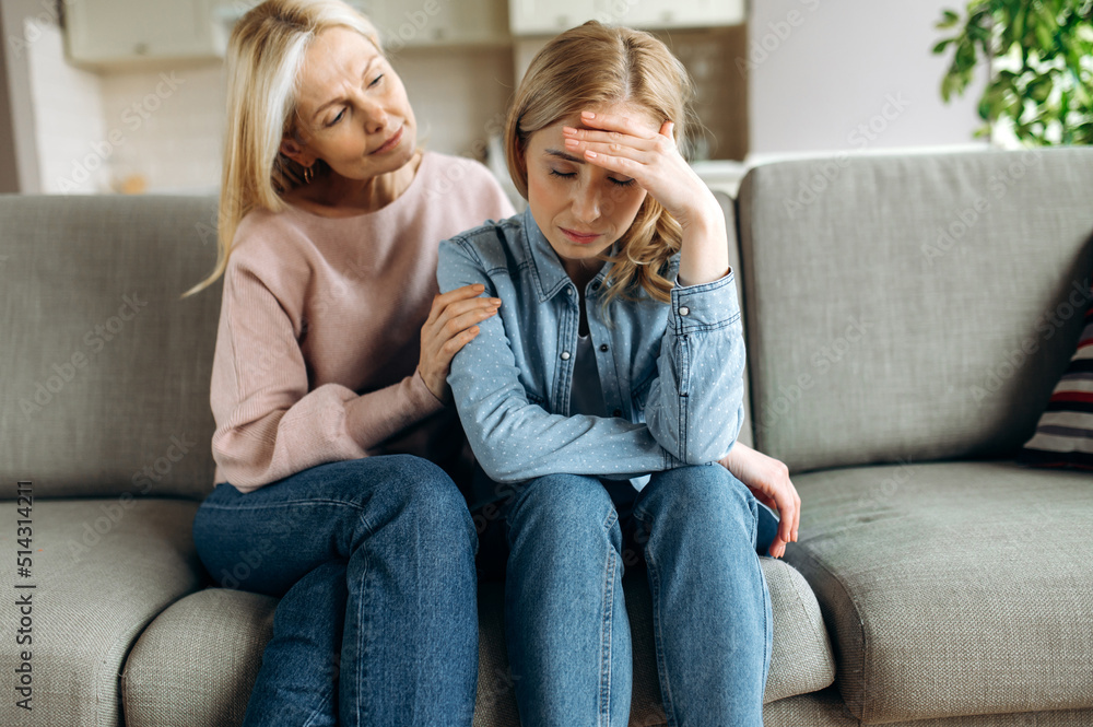 Worried mature mother consoles her adult daughter, helping with problem ...