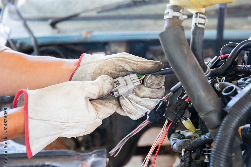 Auto mechanic doing car service and maintenance. Car wiring with ...