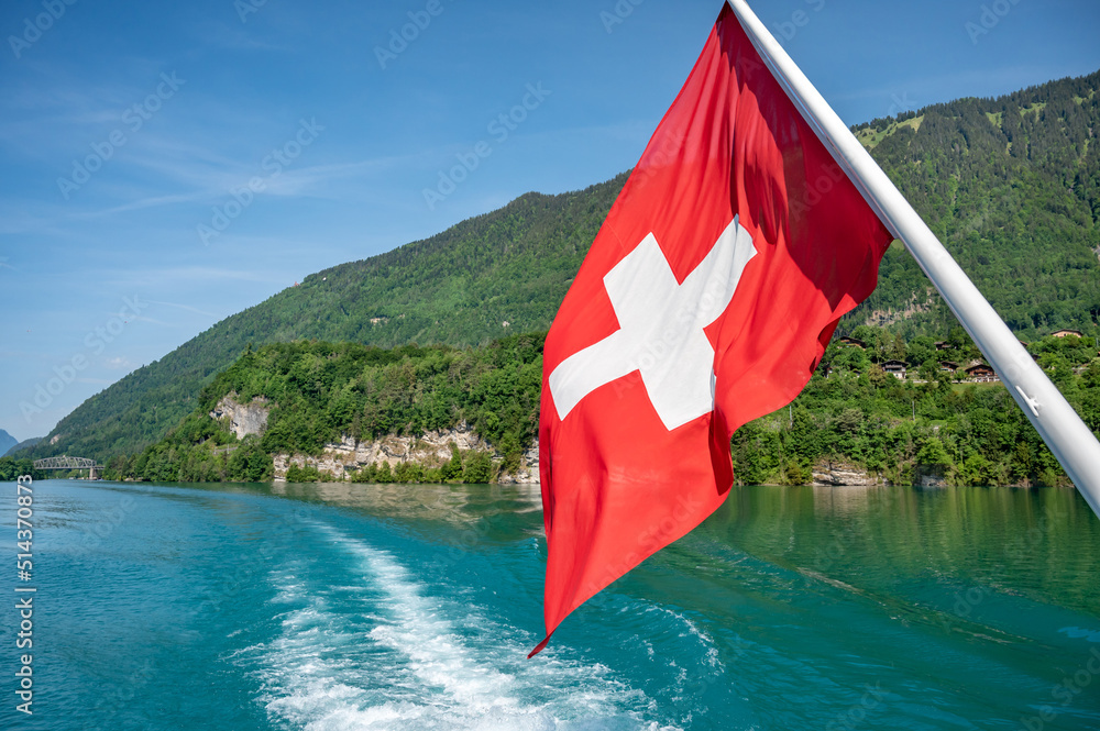 Swiss flag over landscape of lake Brienz. Interlaken, Switzerland ...