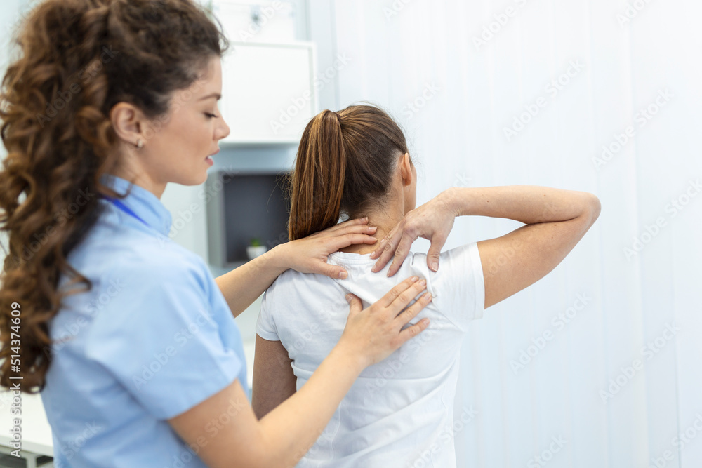 Woman doctor osteopath in medical uniform fixing woman patients ...