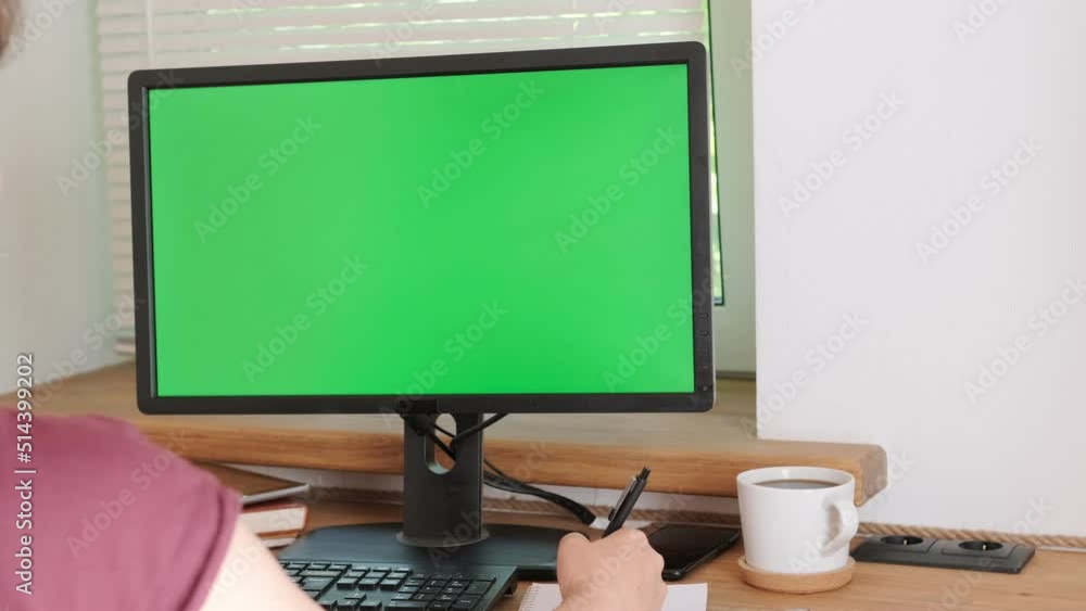 Corporate employee using computer with horizontal green screen for ...