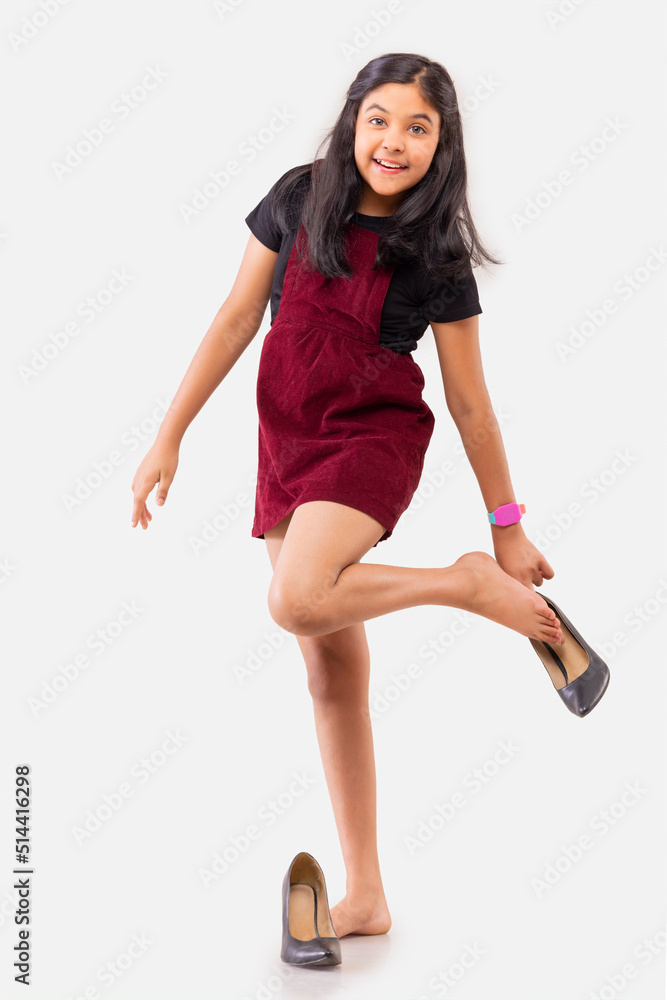 Portrait of little girl trying on high heel shoes Stock Photo | Adobe Stock