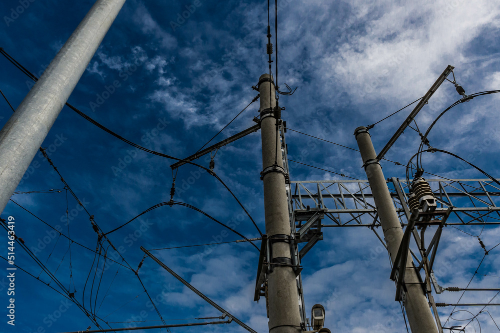 large concrete poles of power lines with wires, coils, metal structures ...