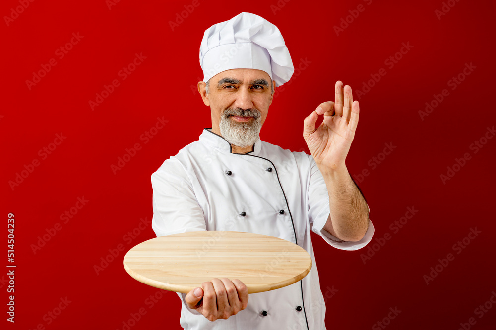 Chef-cooker in a chef's hat and jacket holding an empty wooden tray for ...