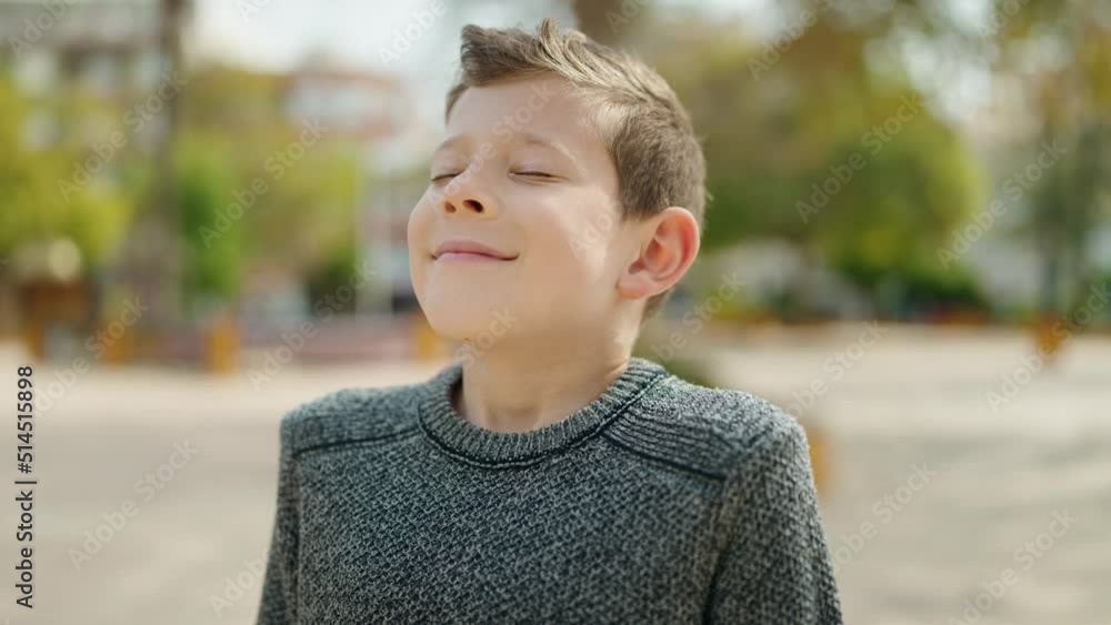 Blond child smiling confident breathing at park Stock Video | Adobe Stock