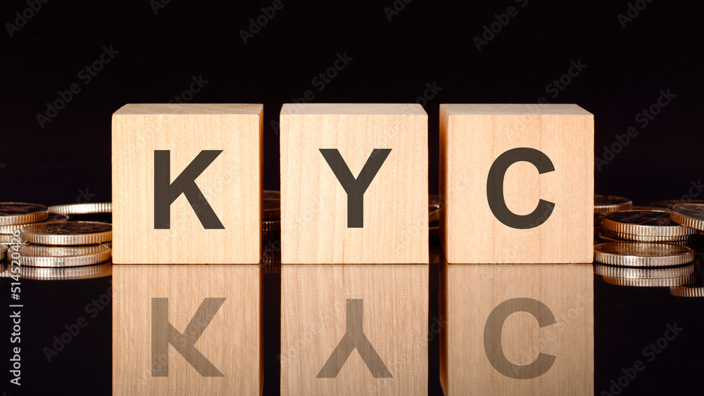 KYC - text on wood blocks on black background with coins. front view ...