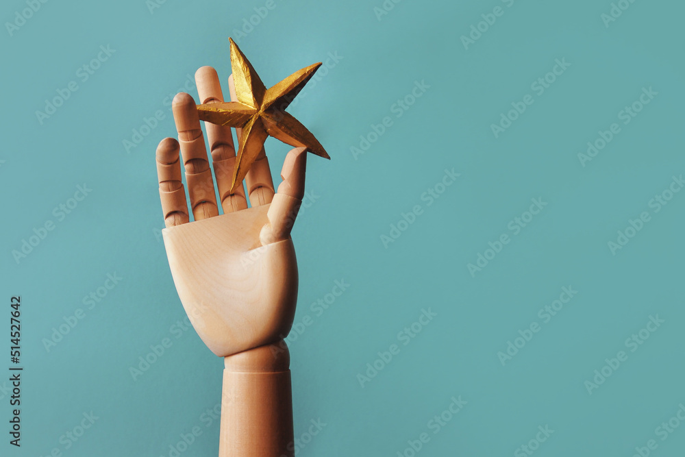 A star in your hand, striving for a dream. A golden star in a wooden ...