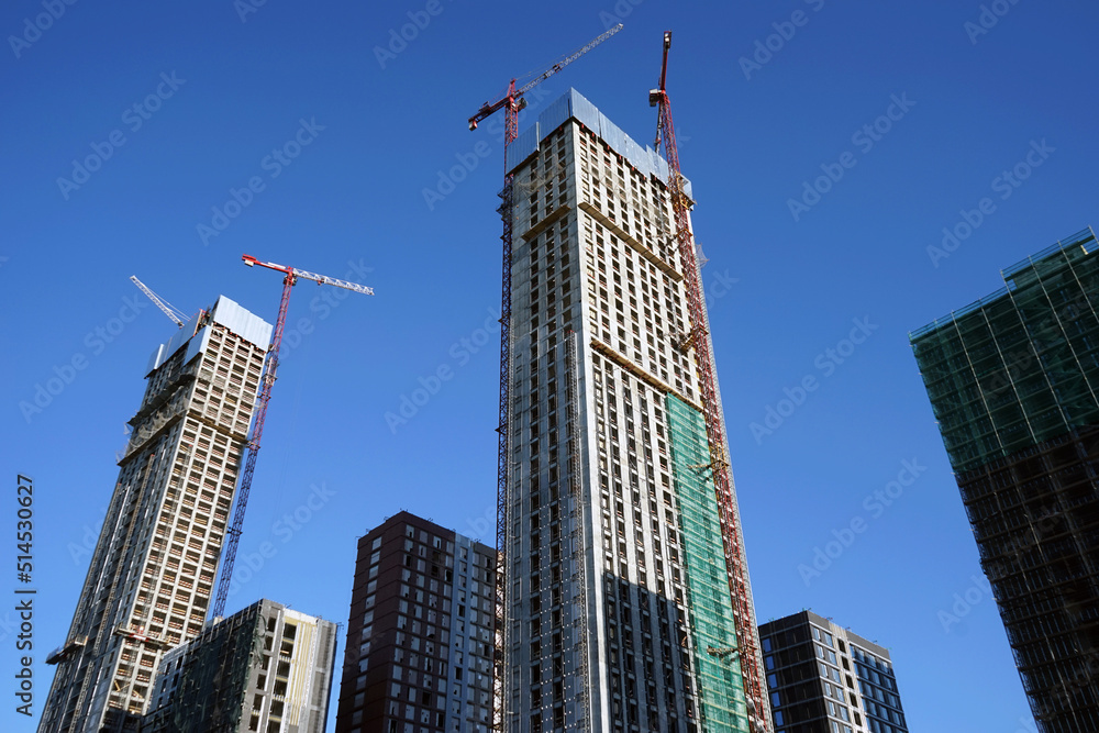 High-rise buildings under construction against a clear blue sky ...