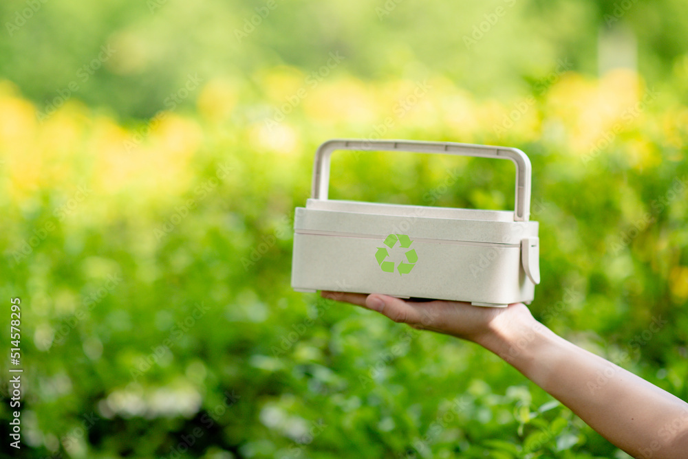 Foto de Hand holding Reusable food box with green recycle symbol ...