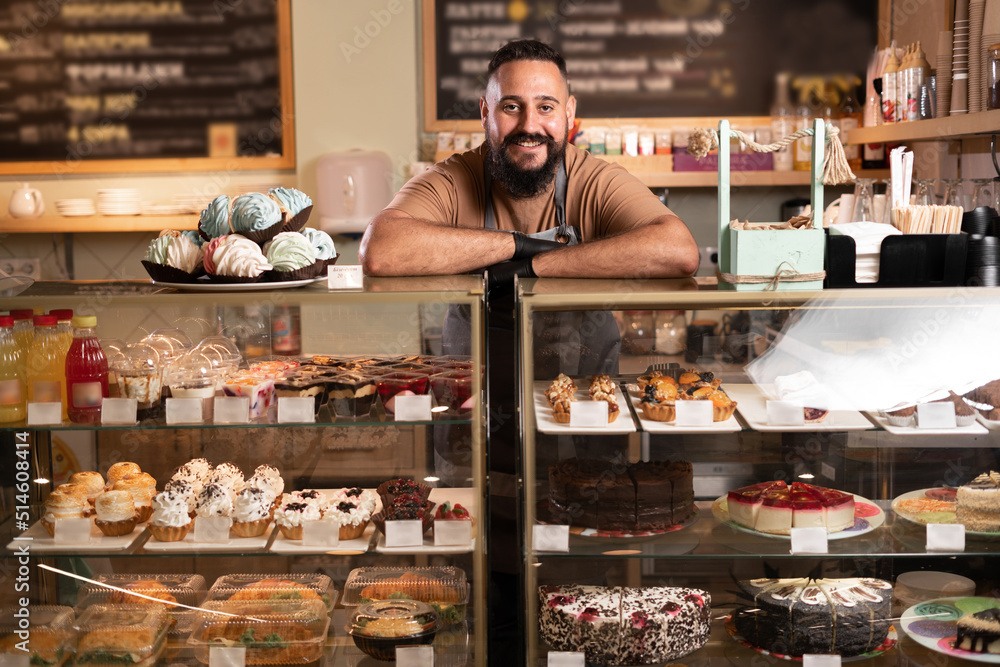 Cheerful indian male baker welcoming you at his bakery store, bearded ...