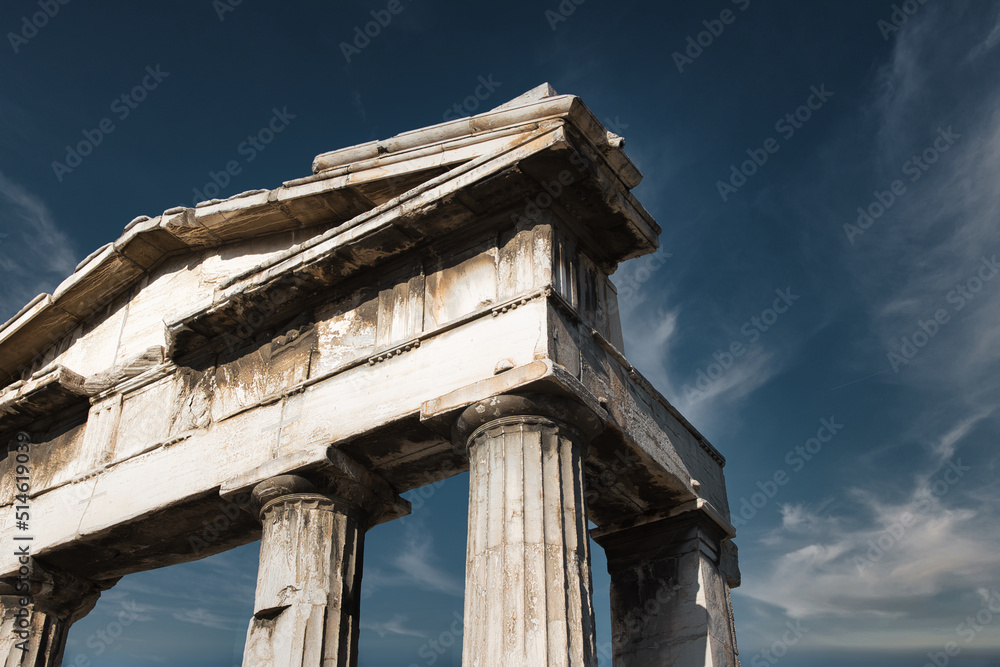 Diagonal view of a Greek ancient arch. Remains of an old temple stand ...