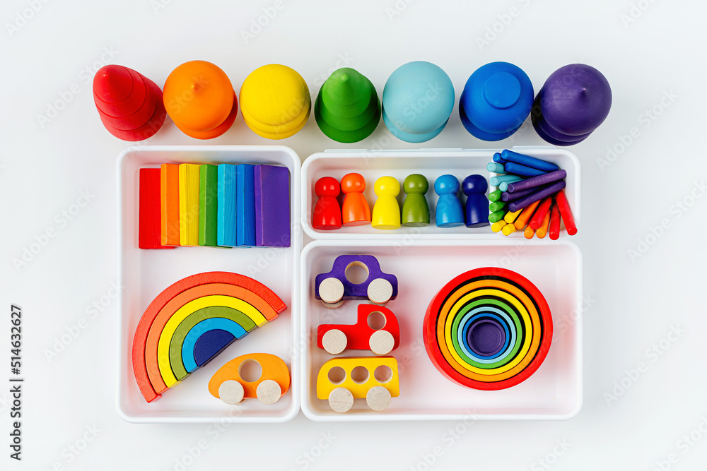 Colorful wooden toys in the colors of the rainbow in plastic box ...
