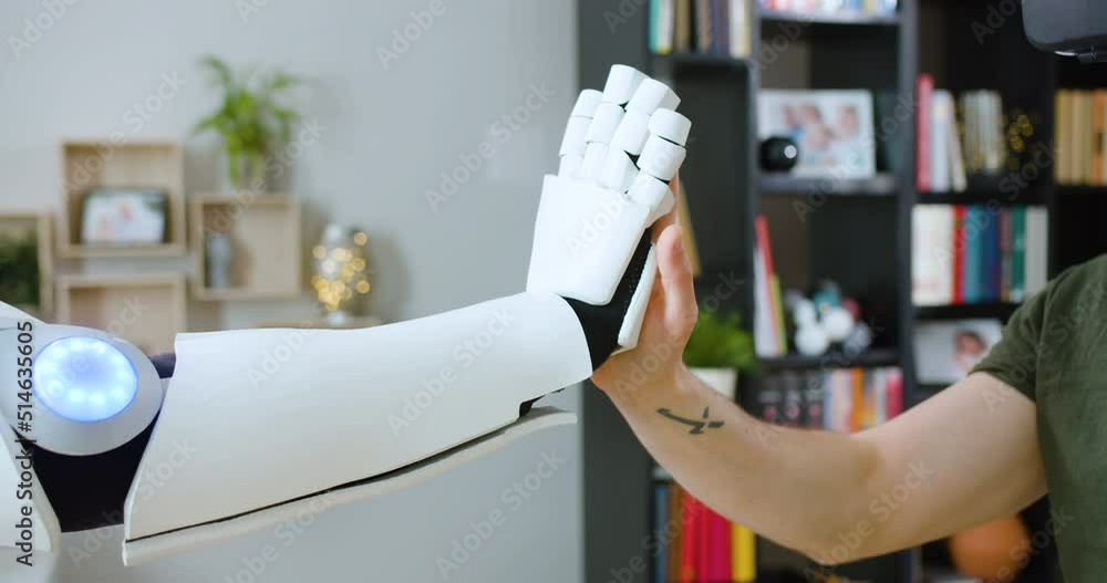 Close up of hands of caucasian man and humanoid robot making high five ...