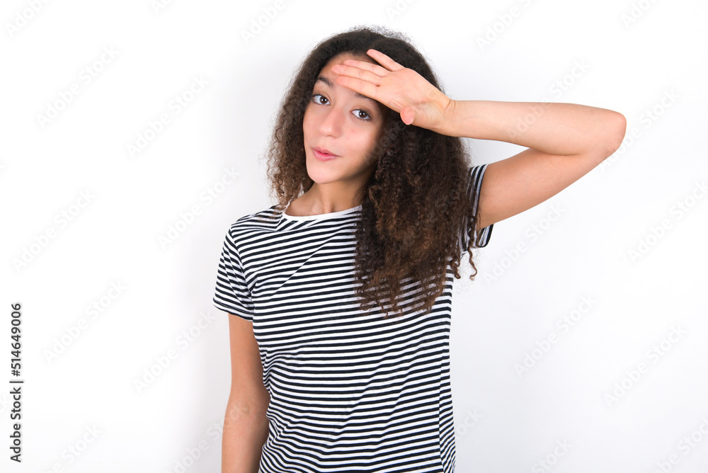 young beautiful girl with afro hairstyle wearing striped t-shirt wiping ...