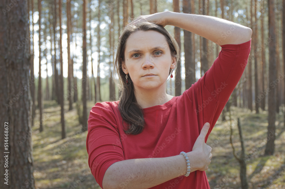 Person practicing EFT in nature forest. Female tapping point under arm ...