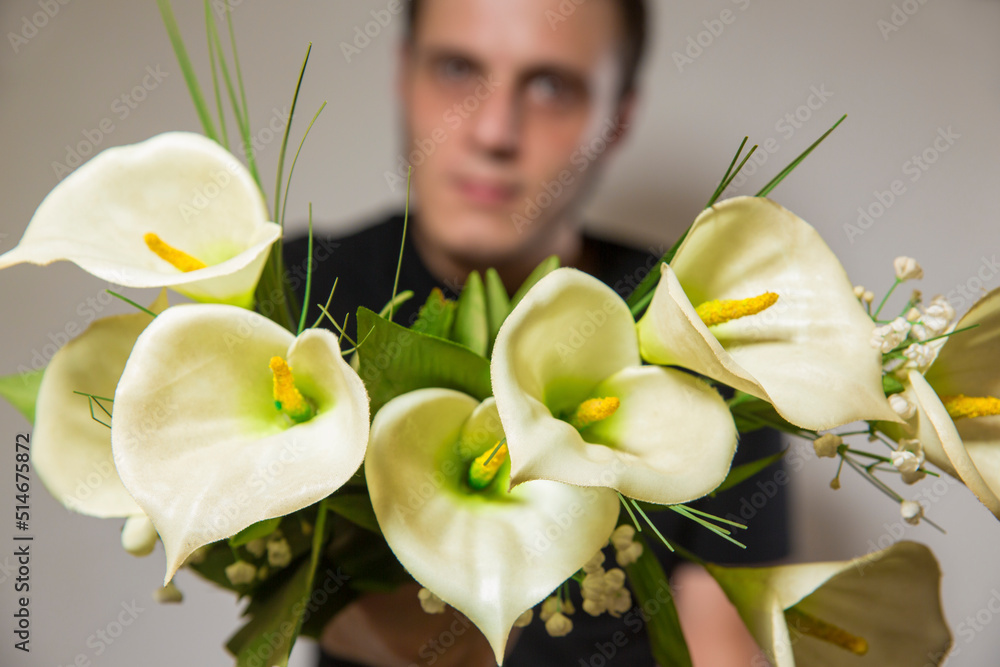 Young boy in love with a bouquet of white flowers of Zantedeschia ...