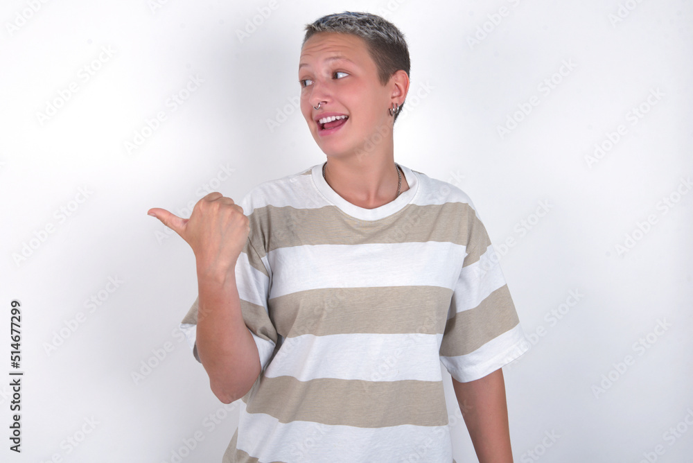Stupefied young woman with short hair wearing striped t-shirt with ...