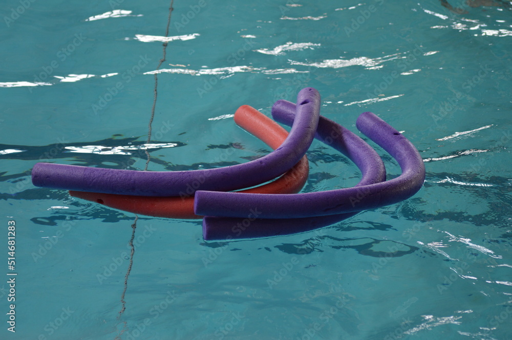 Three purple and one red swimming floating foam in the pool, equipment ...