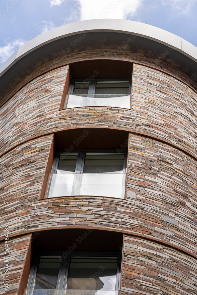 Rounded building, in stone, seen from below on its windows and its ...