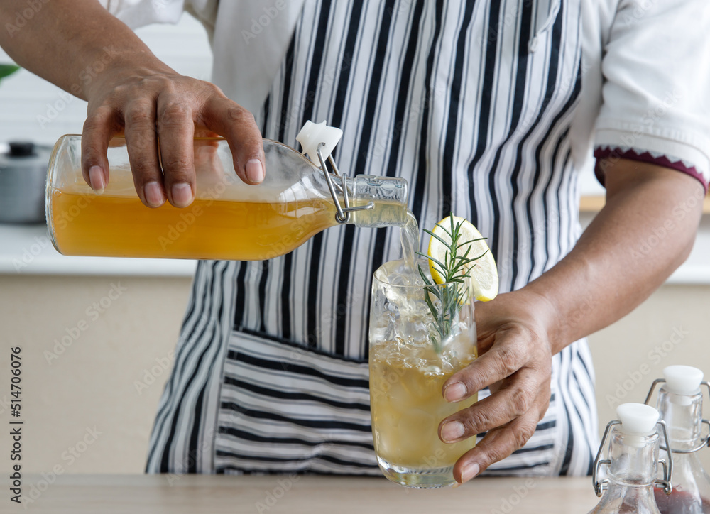 Hand of Man pouring Kombucha tea into a glass, Kombucha fermented drink ...