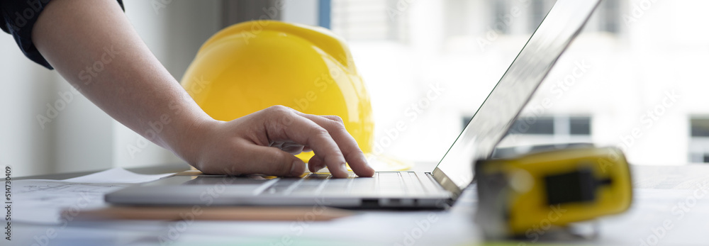 Young man with a laptop plotting a system of building structures in ...