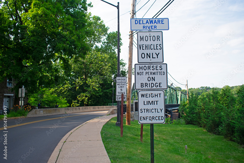 Road limits and restriction signs on approach to truss bridge heading ...