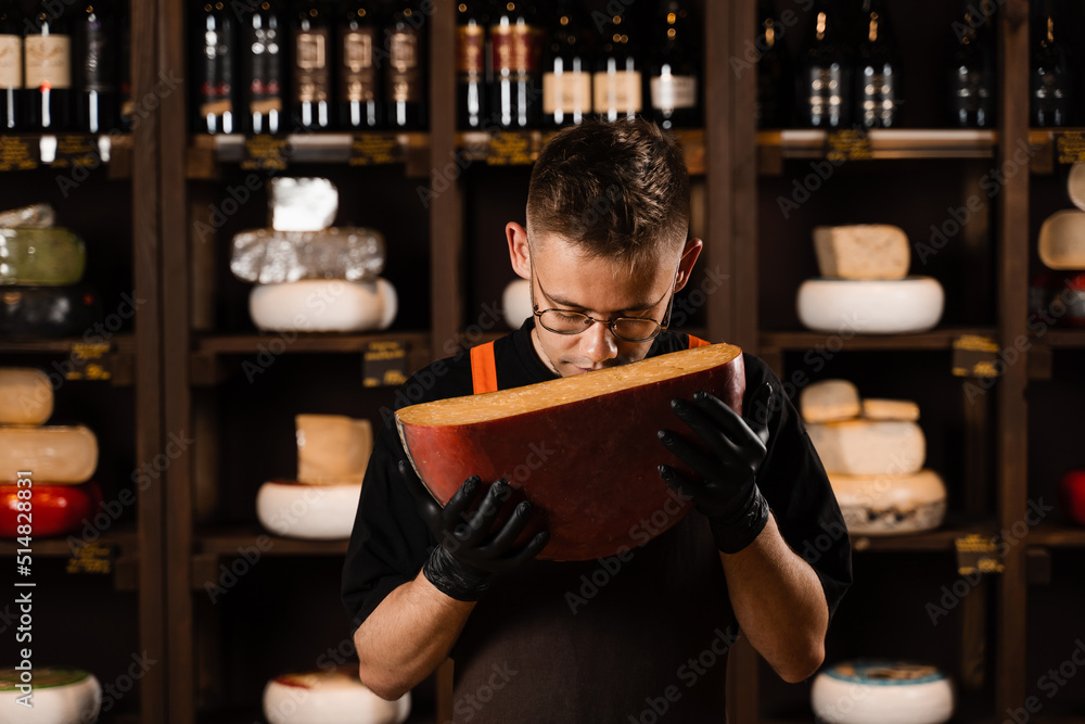 Handsome cheese sommelier holding and sniff limited gouda cheese. Snack ...