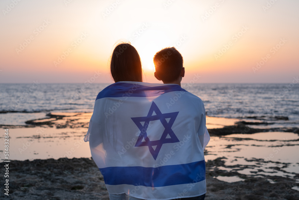Teenagers, young women and man with the Flag of Israel draped over ...