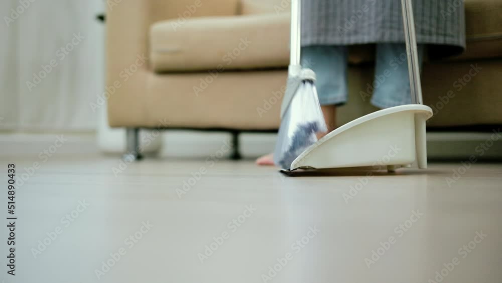 Close Up Hand Of Housewife Using Broom And Dustpan Wearing An Apron To