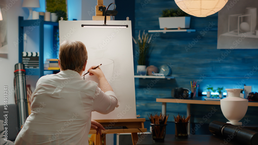 Retired woman drawing outline sketch of vase model, creating ...