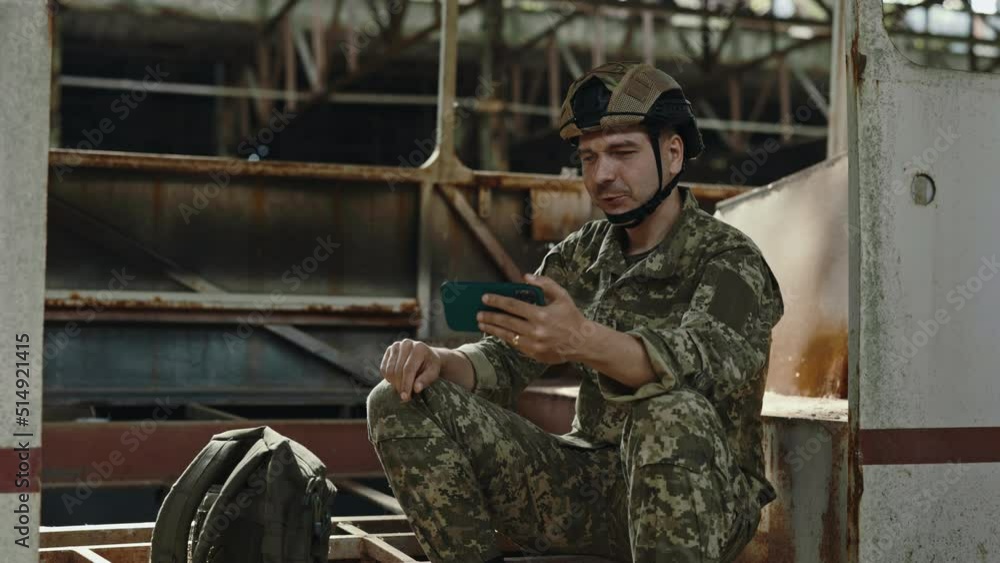 Special forces soldier using digital smartphone to make video call with ...