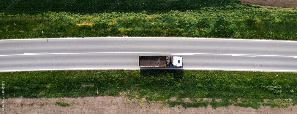 Top view aerial of semi-end dump truck with empty trailer on the road ...