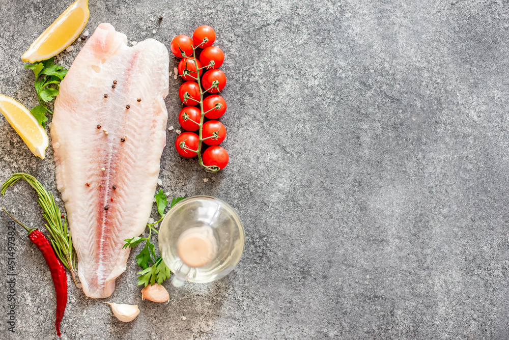 Foto de Fresh raw white fish fillet Pangasius with spices and lemon on ...